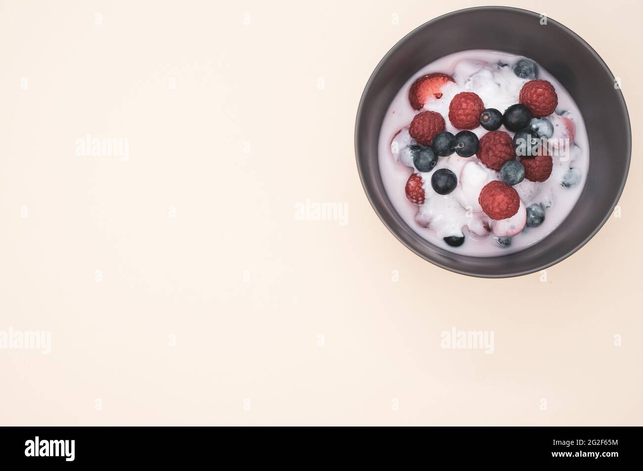 Top view of yogurt with fresh raspberries and blueberries on a bowl ...