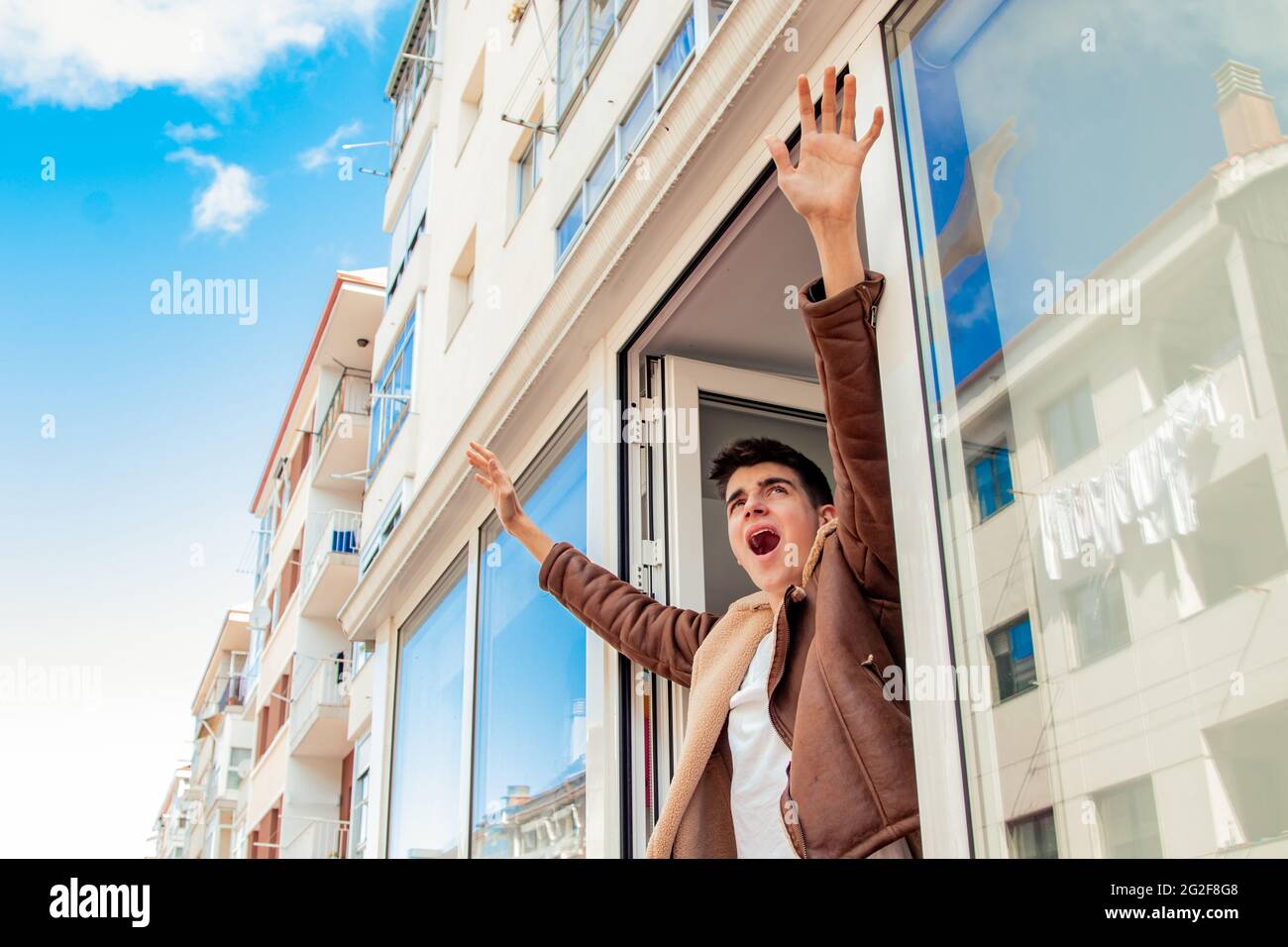 young man screaming at the window or terrace of the house Stock Photo ...