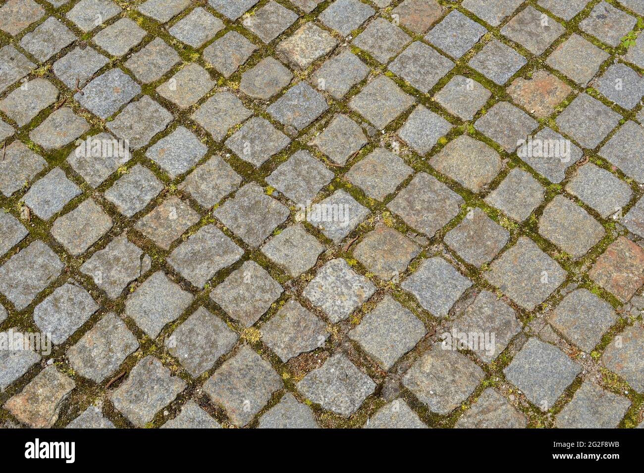 The background of the old textured cobblestone pavement. In diagonal ...