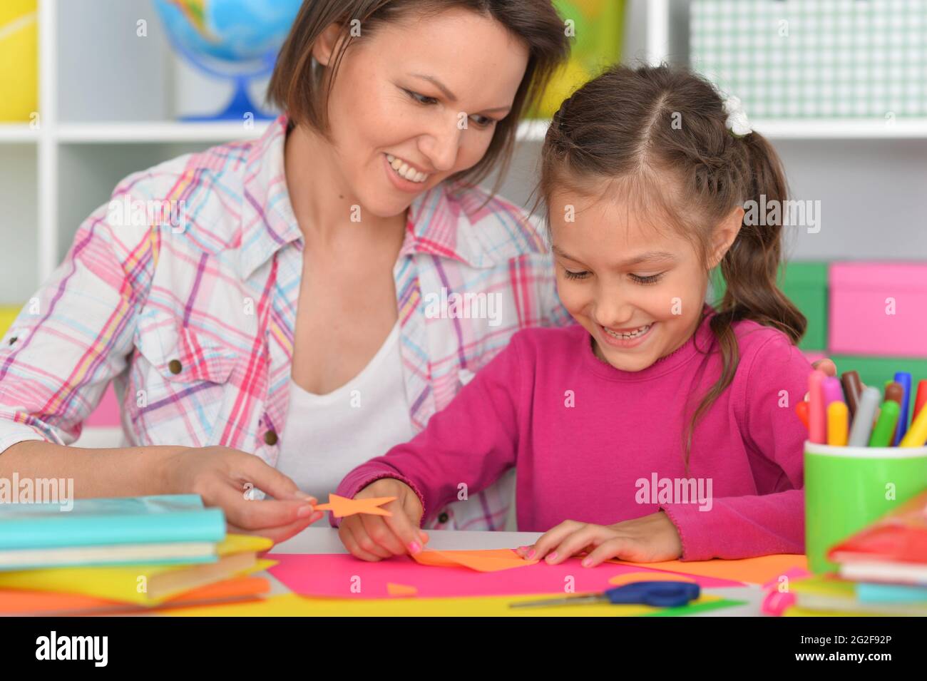 Mother teaches her cute daughter to do craft items Stock Photo - Alamy