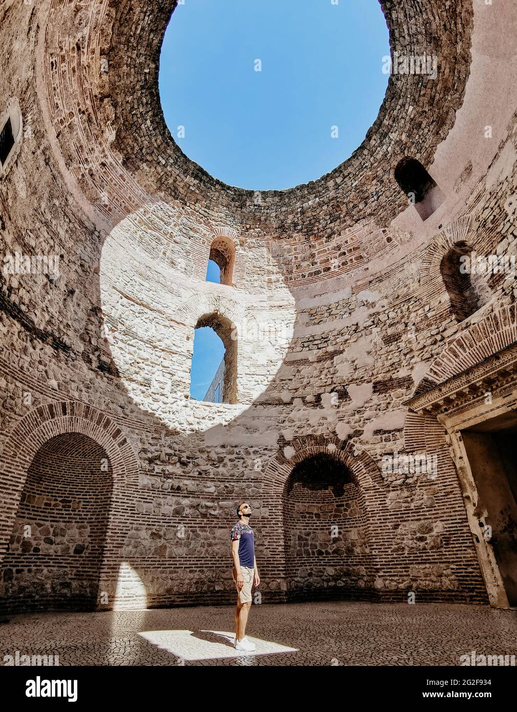 Man standing inside ancient roman building with natural light shining ...