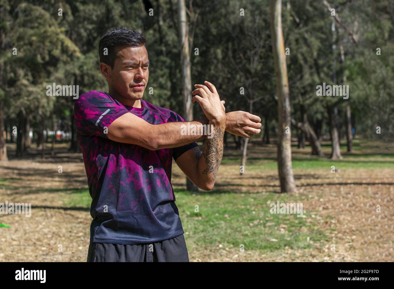 latin fit man doing arm stretching exercises. Getting ready and warming ...