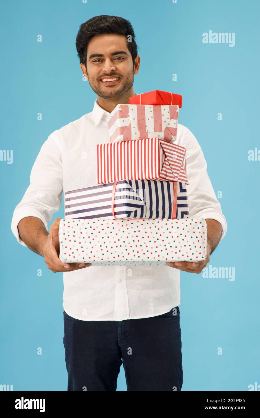 A YOUNG MAN HAPPILY STANDING WITH GIFTS IN HAND Stock Photo - Alamy