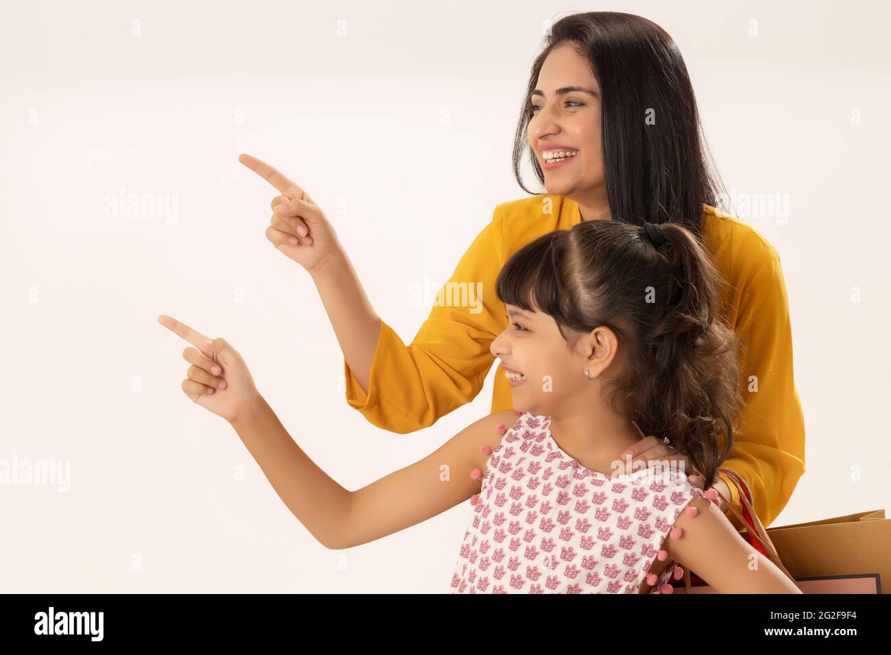 A HAPPY MOTHER AND DAUGHTER TOGETHER POINTING AWAY ASIDE Stock Photo ...