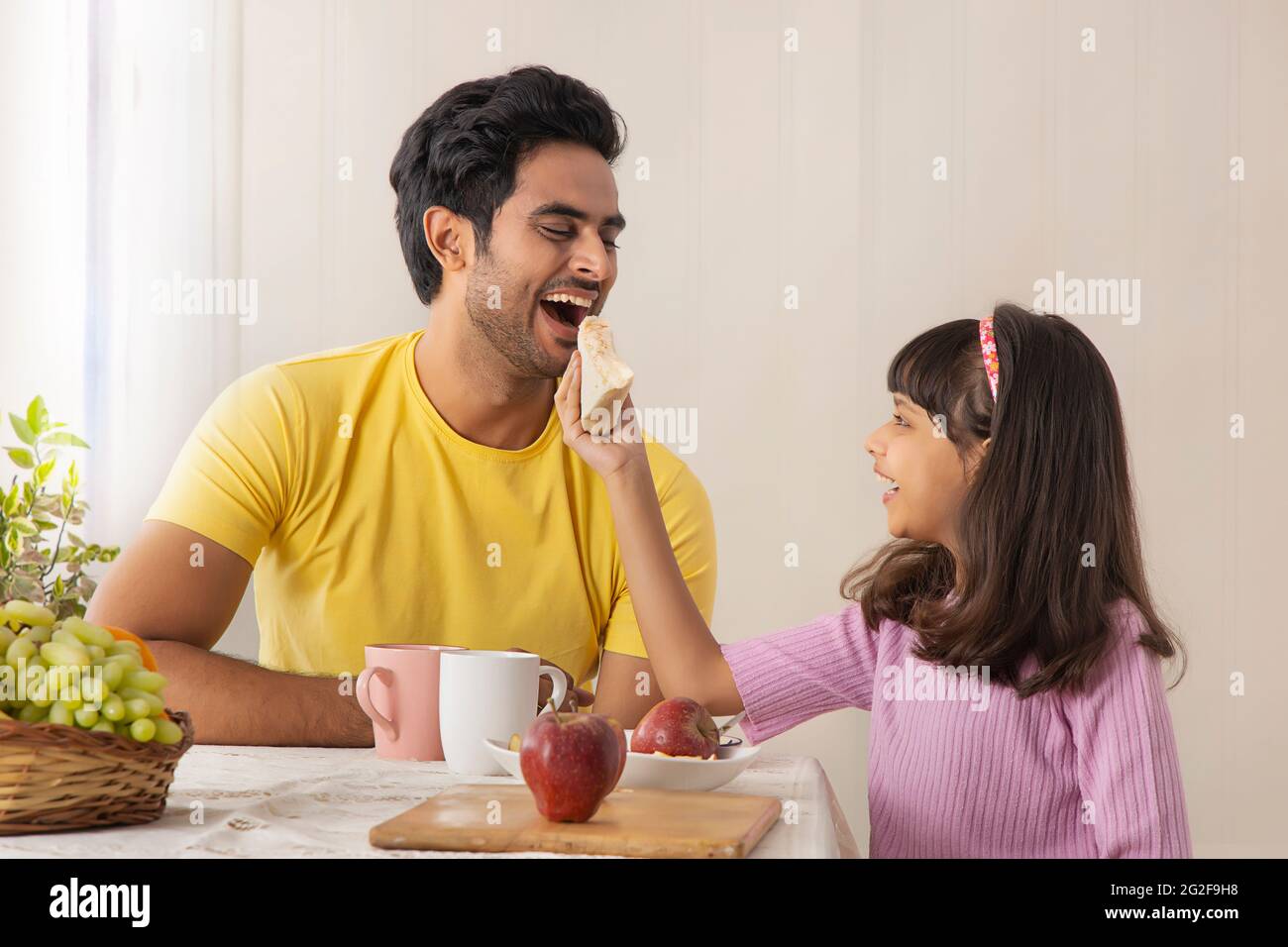 A YOUNG CHILD HAPPILY GIVING SANDWICH TO HER FATHER Stock Photo - Alamy