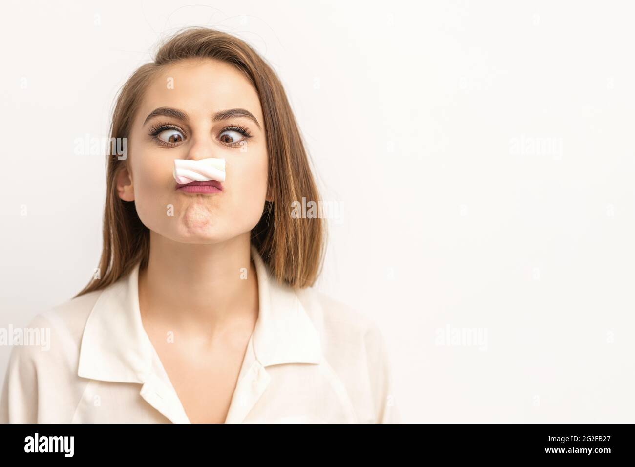 Young funny woman with sweet candy marshmallow-like mustache over white ...
