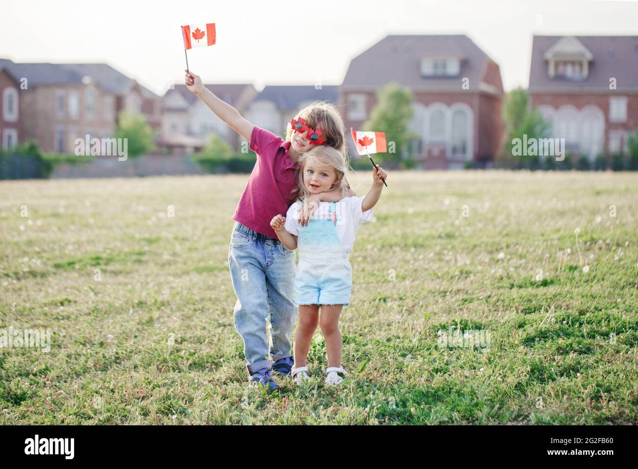 Happy Canada Day. Caucasian siblings brother and sister holding waving ...