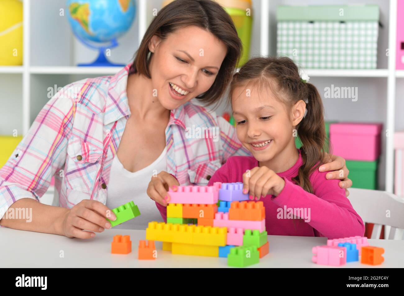 Cute little girl playing with colorful clay blocks at home Stock Photo ...