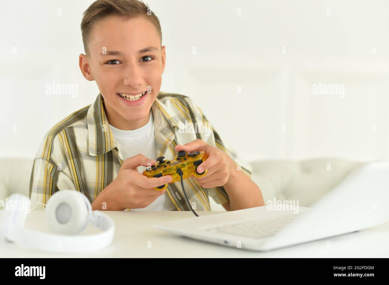 Cute boy in using laptop at home playing game Stock Photo - Alamy