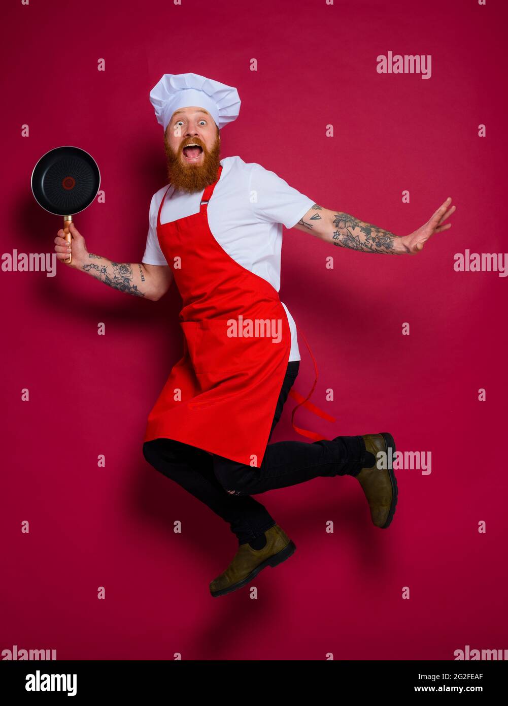 scared chef with beard and red apron jumps Stock Photo - Alamy