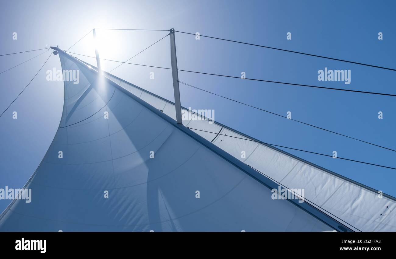 Yacht wind filled sails on clear blue sky background. Sailing with the ...