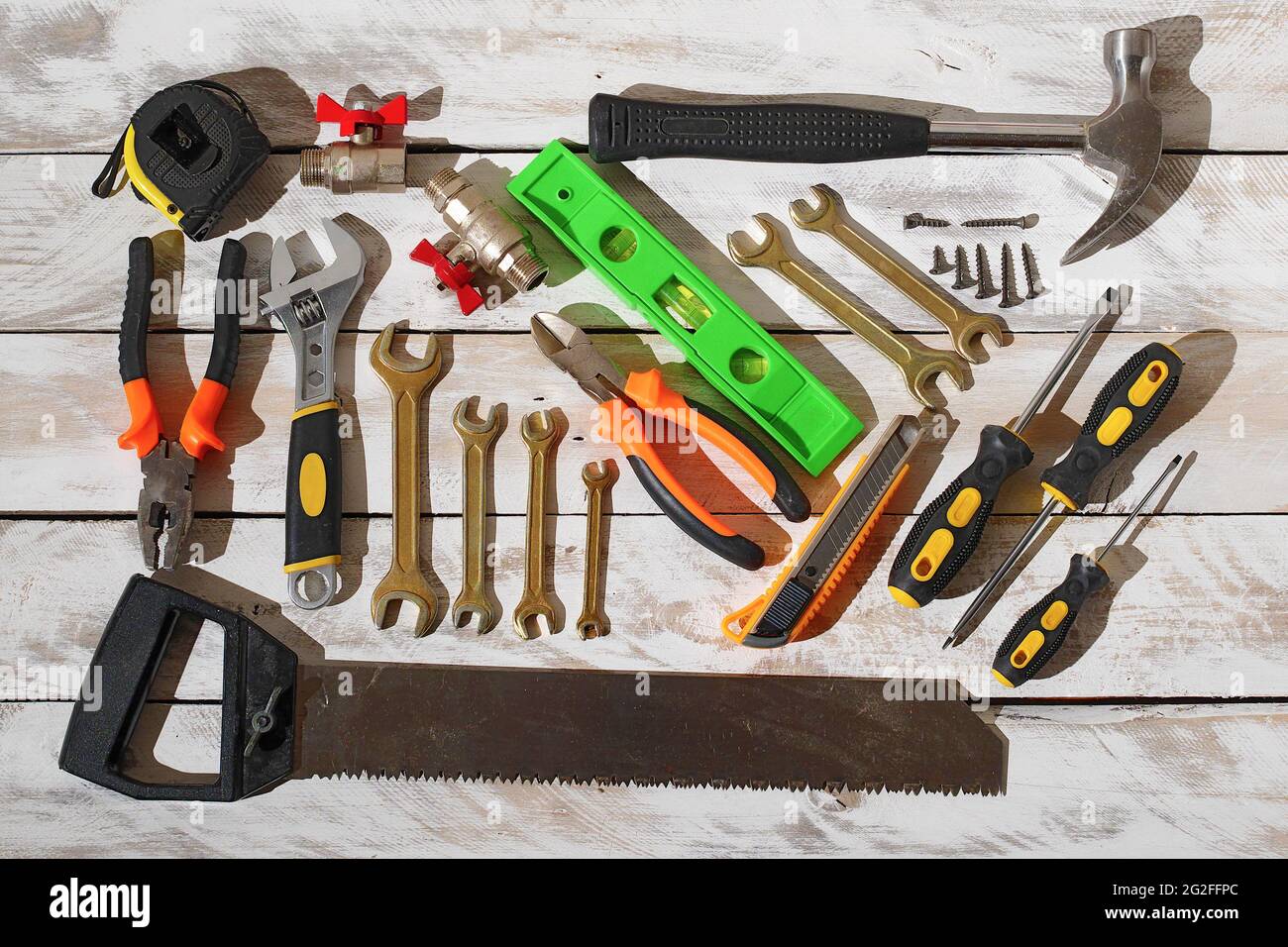 Top view of various handyman tools on wooden table with hard light and ...