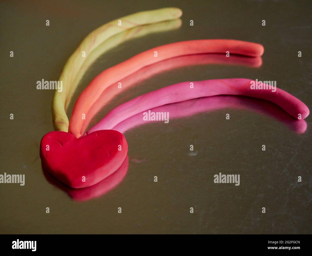 Clay Hearts with three colors rays on reflected glass surface Stock ...