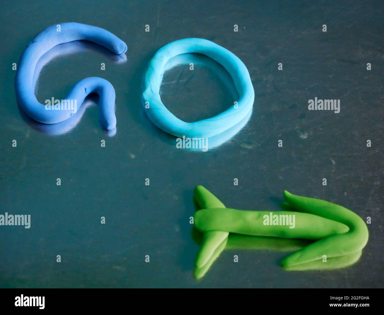 Go text with green arrow made with clay soil on glass surface Stock ...