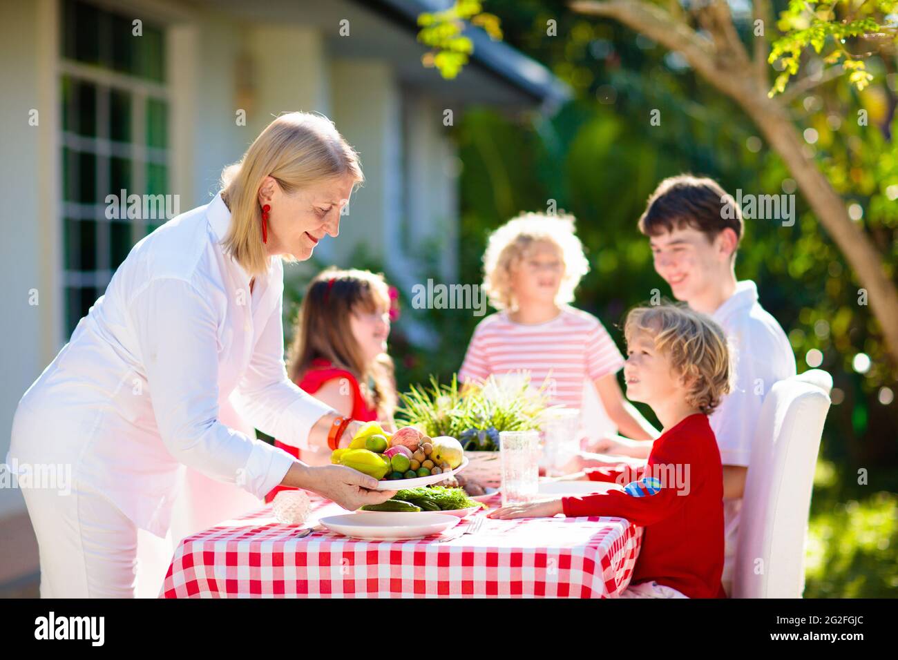 Family eating outdoors. Garden summer fun. Barbecue in sunny backyard ...