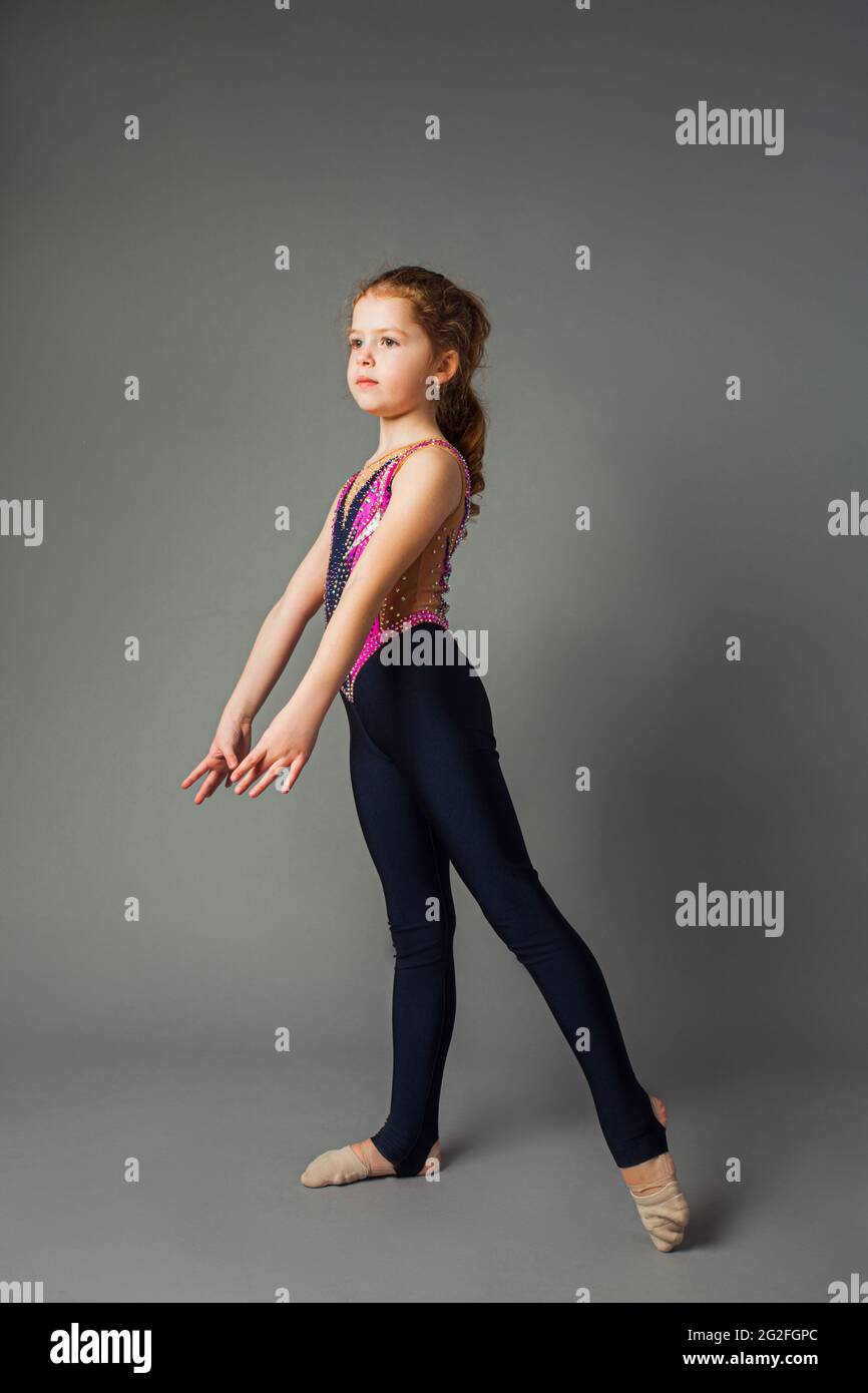 The little girl is stretching in a bright sports costume Stock Photo ...