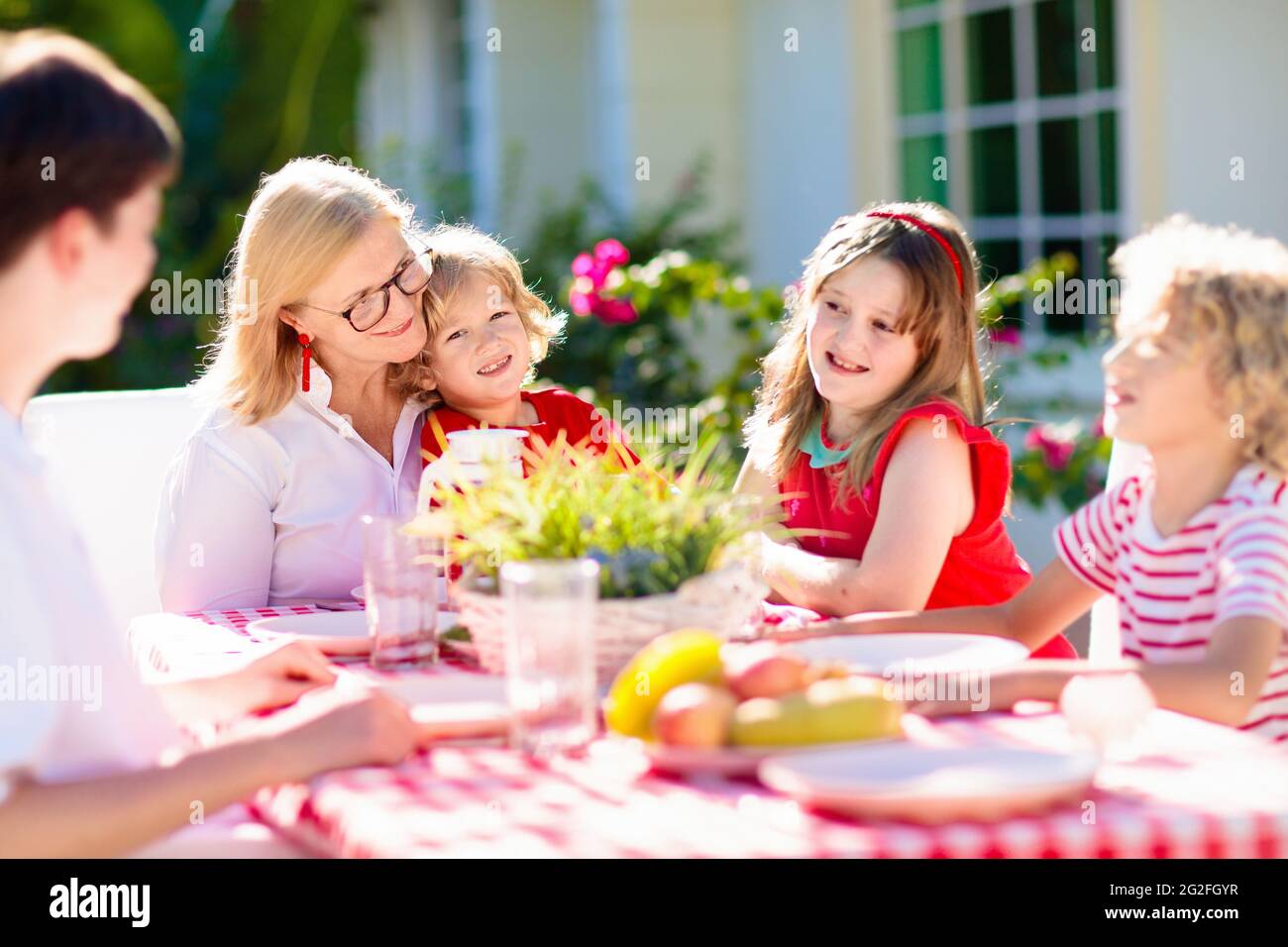Family eating outdoors. Garden summer fun. Barbecue in sunny backyard ...