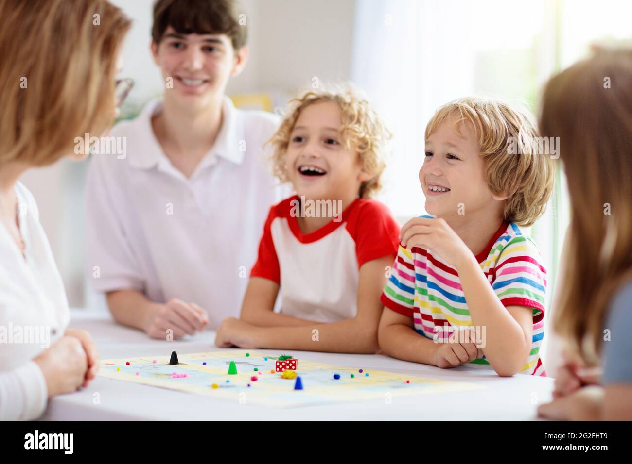 Family playing board game at home. Kids play strategic game. Little boy ...