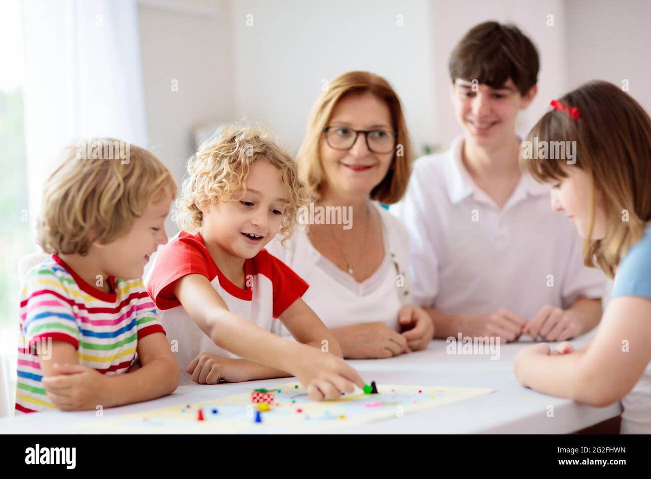 Family playing board game at home. Kids play strategic game. Little boy ...