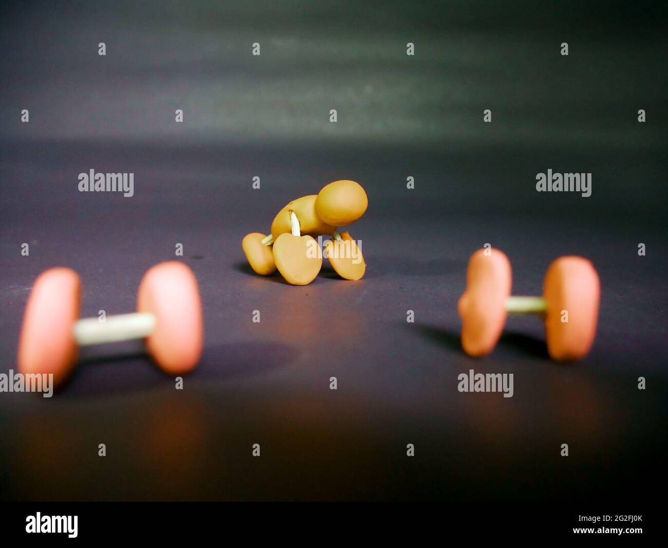 Clay man doing pushups on gym while dumbbell set on front frame Stock ...