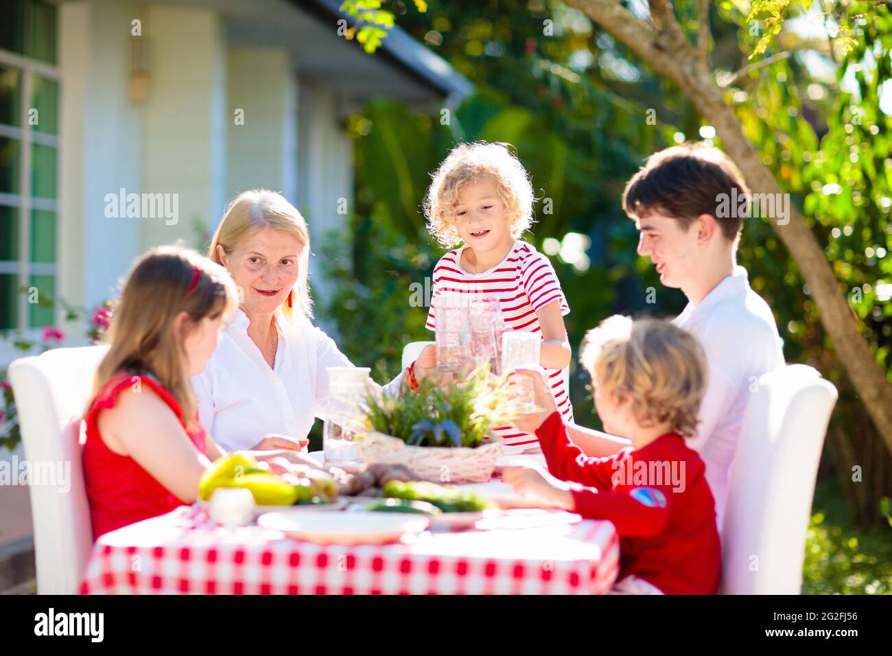 Family eating outdoors. Garden summer fun. Barbecue in sunny backyard ...
