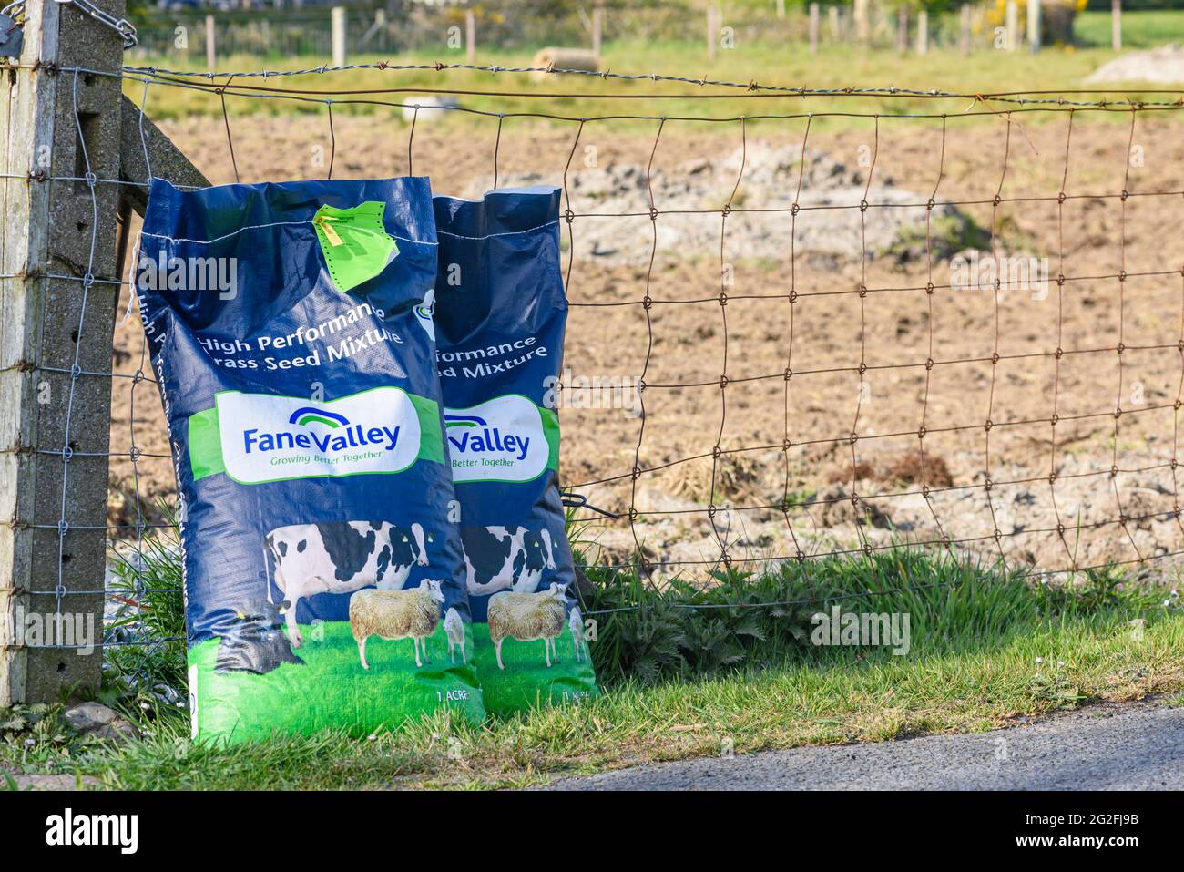 Two bags of farmland field grass seed waiting to be sown at a farm ...