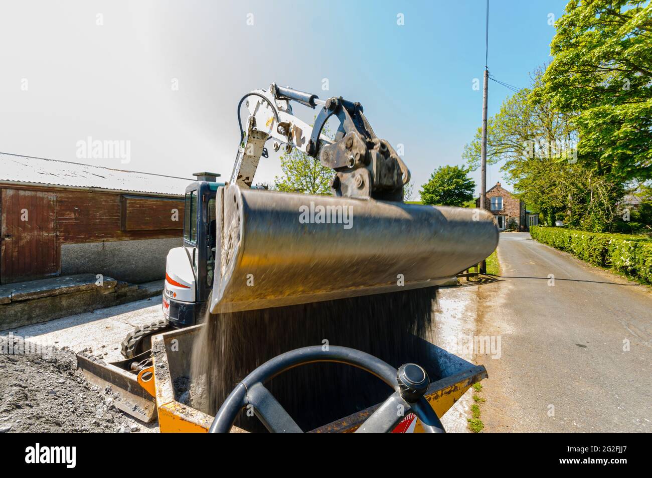 Bobcat E25 mini-digger excavator loads crushed blinding aggregate ...