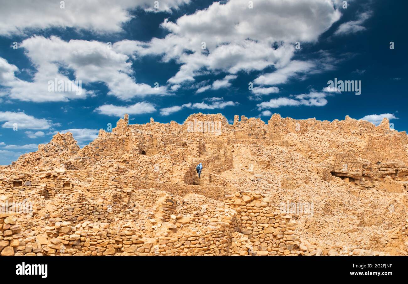 Man dressed in sky blue in the ruins of the ancíent city of Ouadane ...
