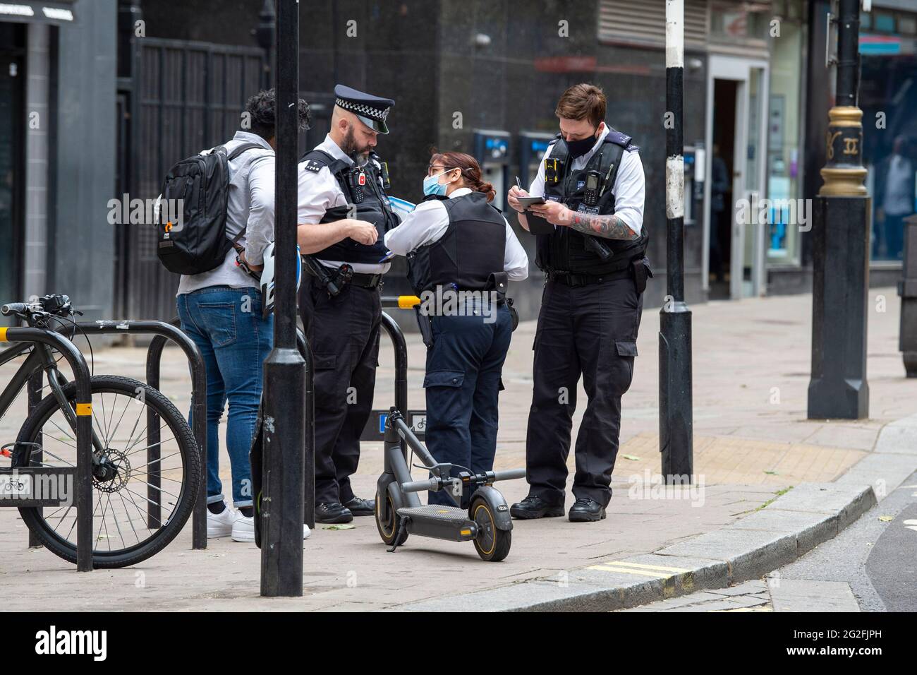 London, UK. 11th June, 2021. Police officers speak to an E-Scooter ...