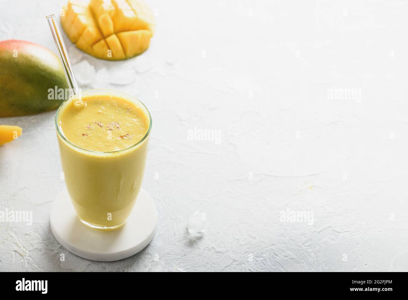 Indian healthy ayurvedic mango lassi on white background with copy ...