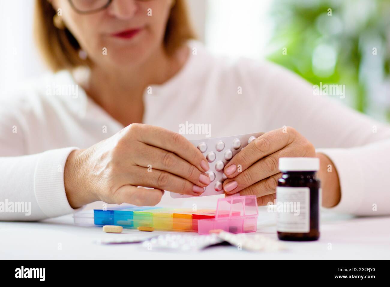 Pill box for senior patient. Medicine container. Elderly woman sorting ...