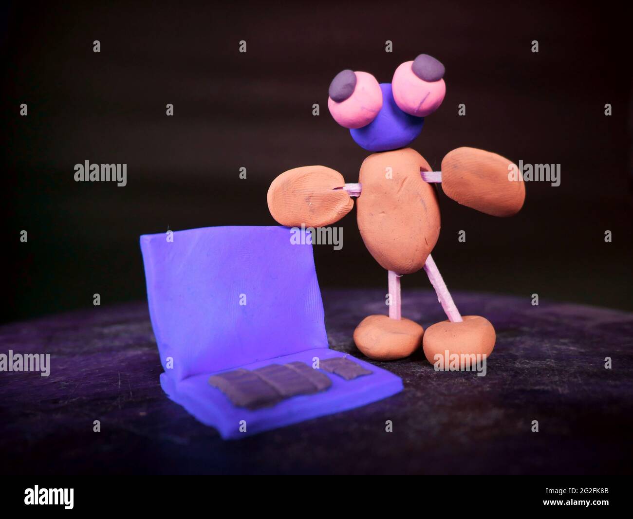 Cartoon clay man stand with laptop on blueish background Stock Photo ...