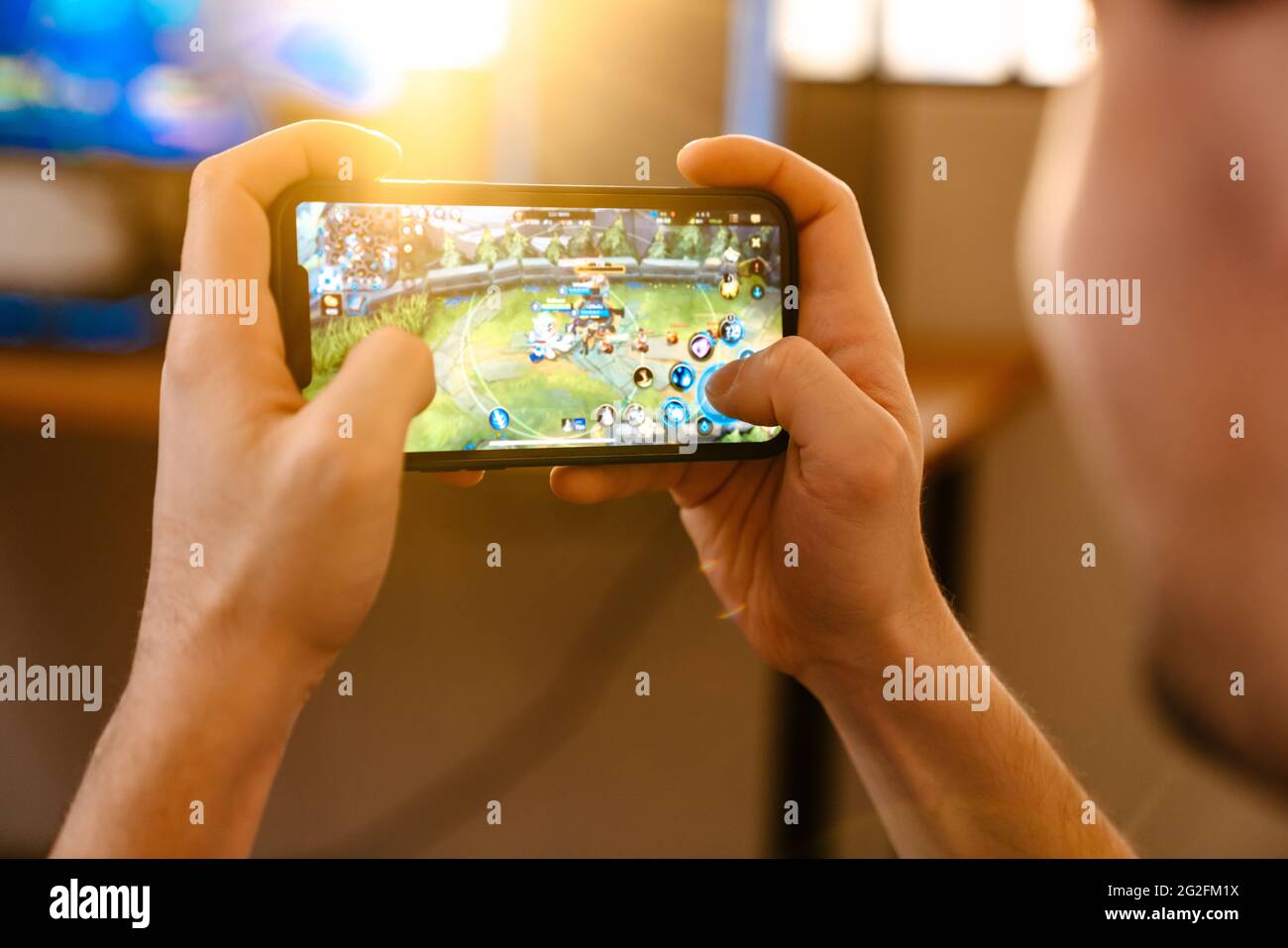 Caucasian guy playing video game on his mobile phone at home Stock ...