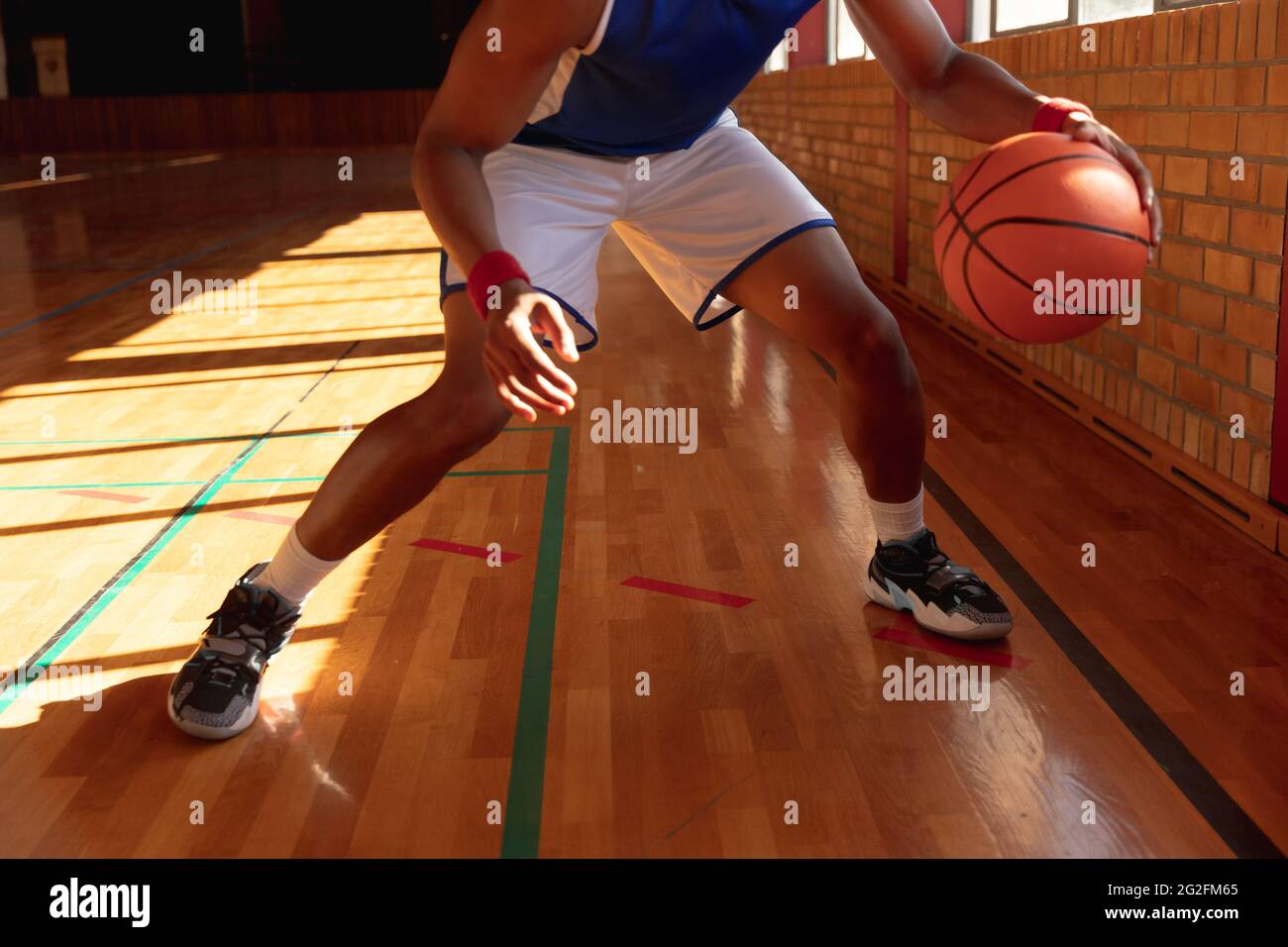 Mixed race male basketball player wearing blue sportswear and practice ...