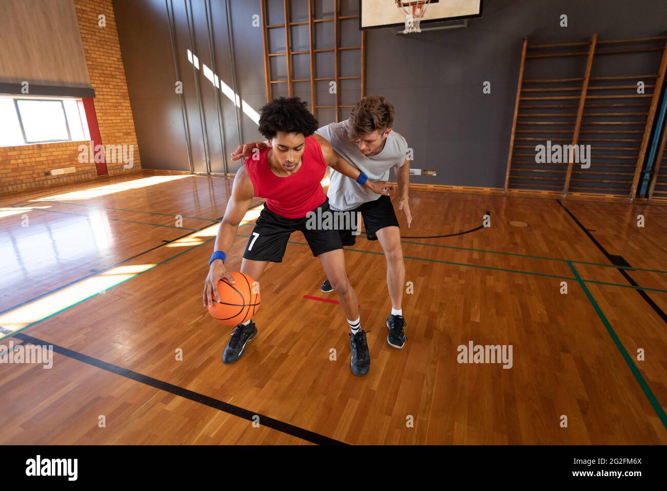 Two diverse male basketball players practice dribbling ball Stock Photo ...