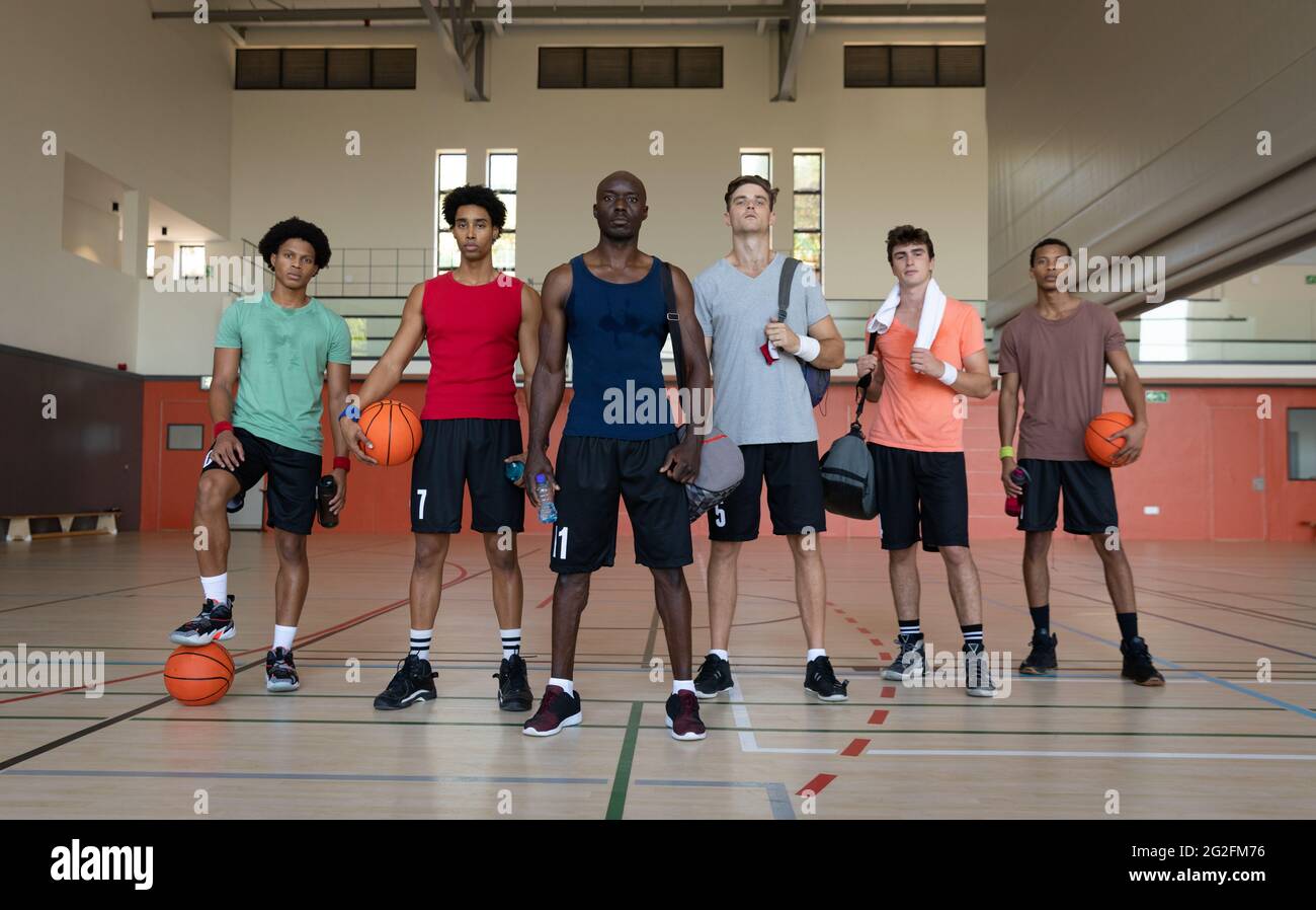 Portrait of diverse male basketball team and coach holding balls Stock ...