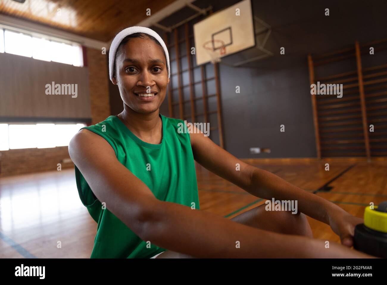 Portrait of mixed race female basketball player with bottle of water ...