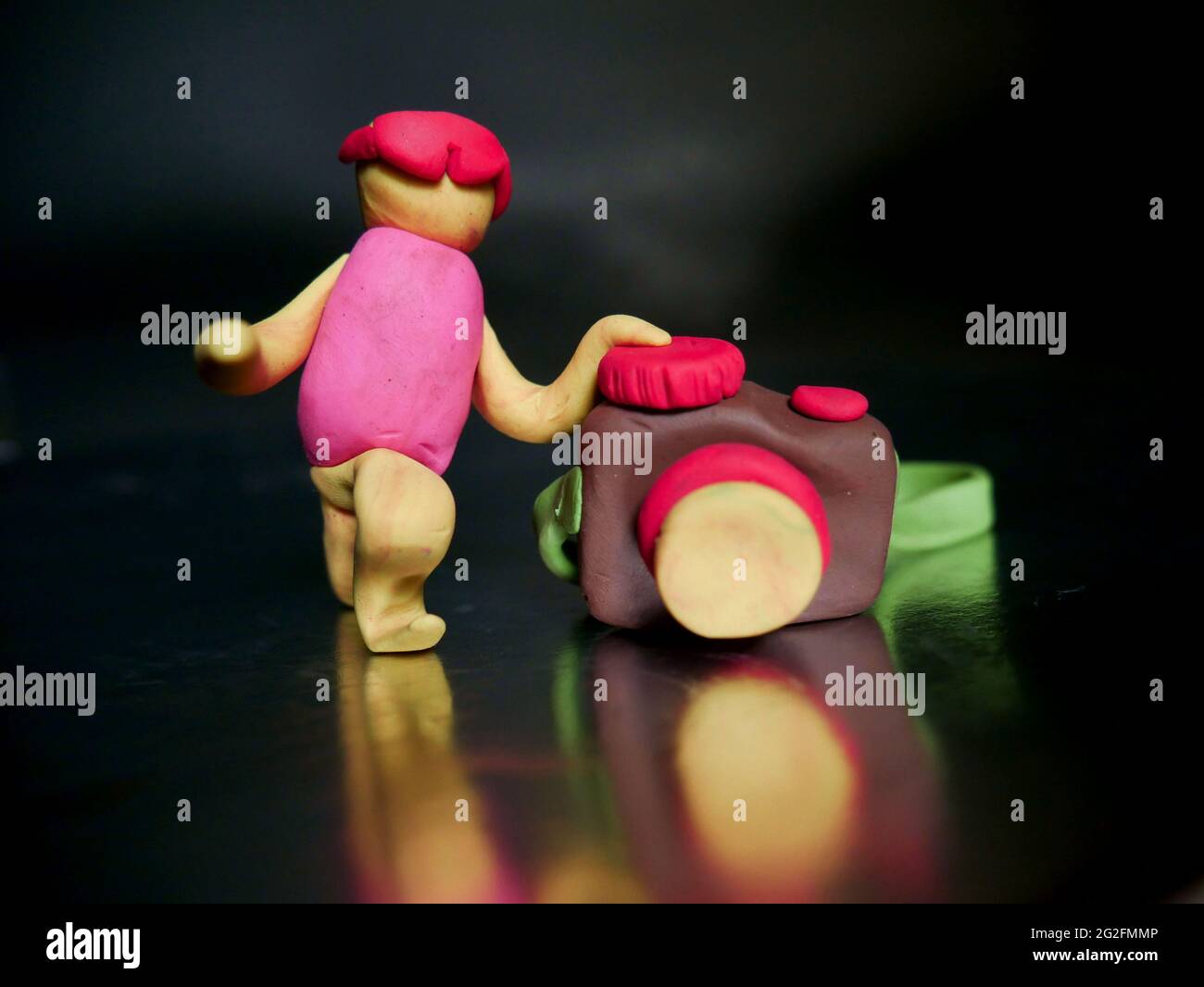 Clay photographer cartoon stand with digital camera on glass surface ...