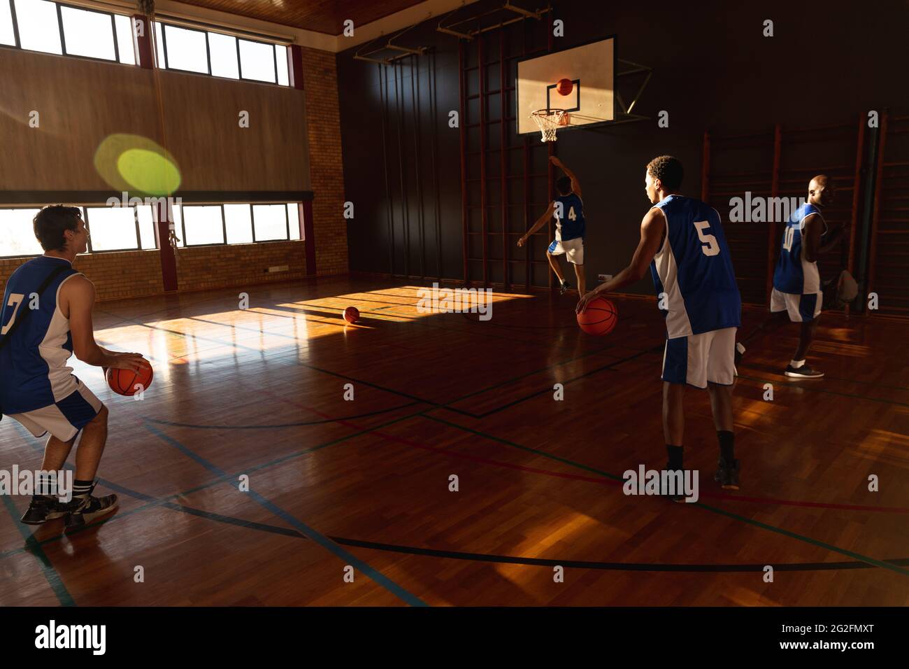 Diverse male basketball team practicing shooting with ball Stock Photo ...