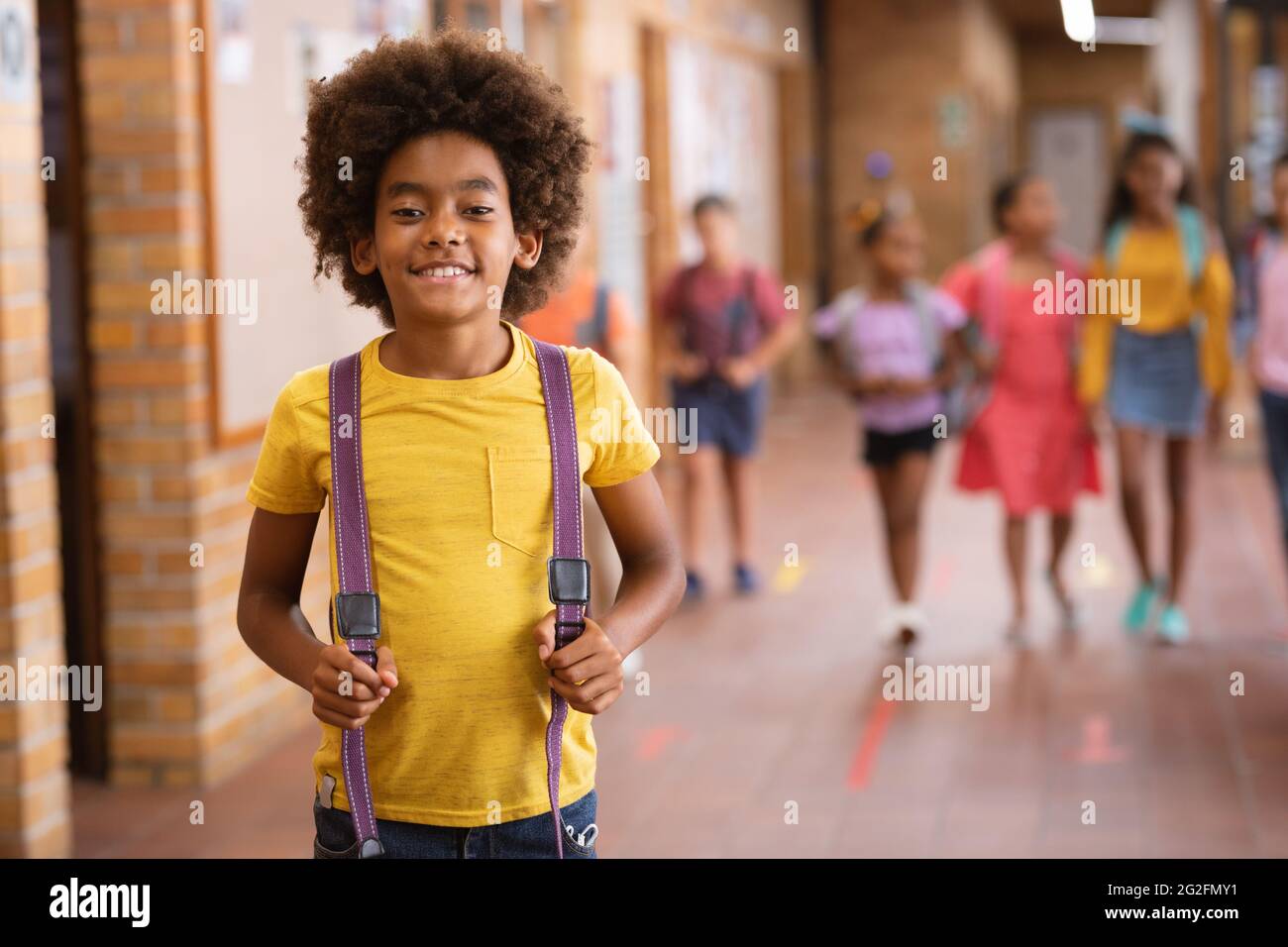 Portrait of african american boy smiling while standing in the corridor ...