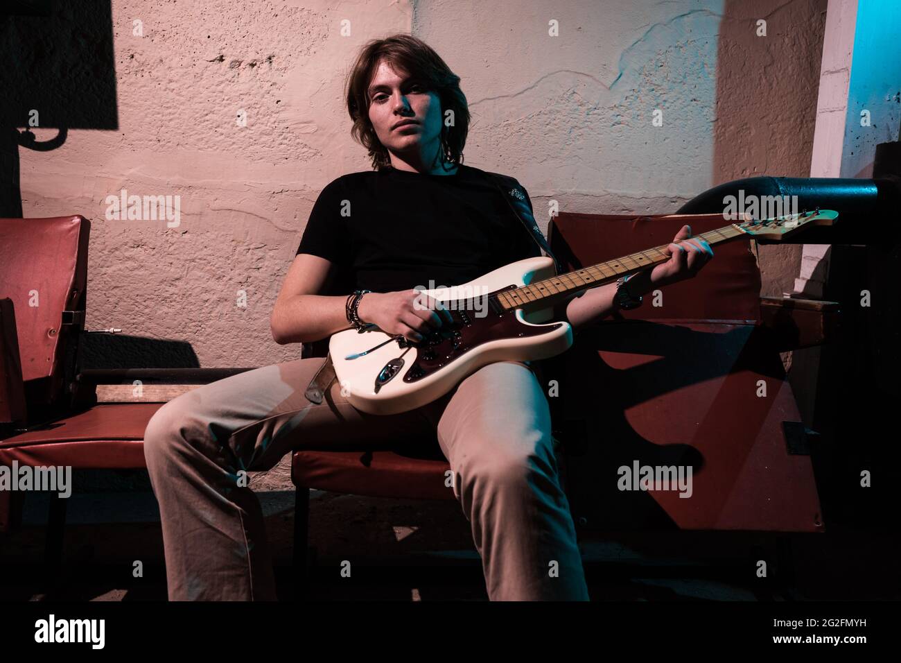 portrait of a musician. Handsome young man with musical instruments ...