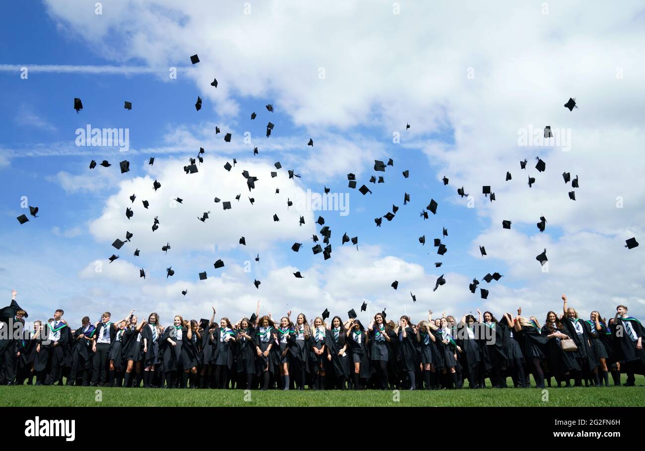 Year 11 pupils throw their mortarboards into the air following a ...