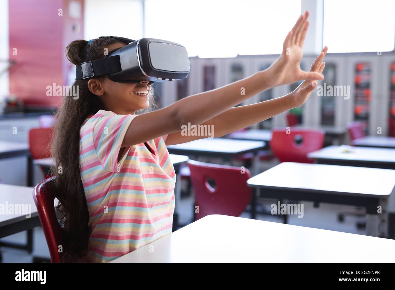 African american girl wearing vr headset gesturing while sitting on her ...