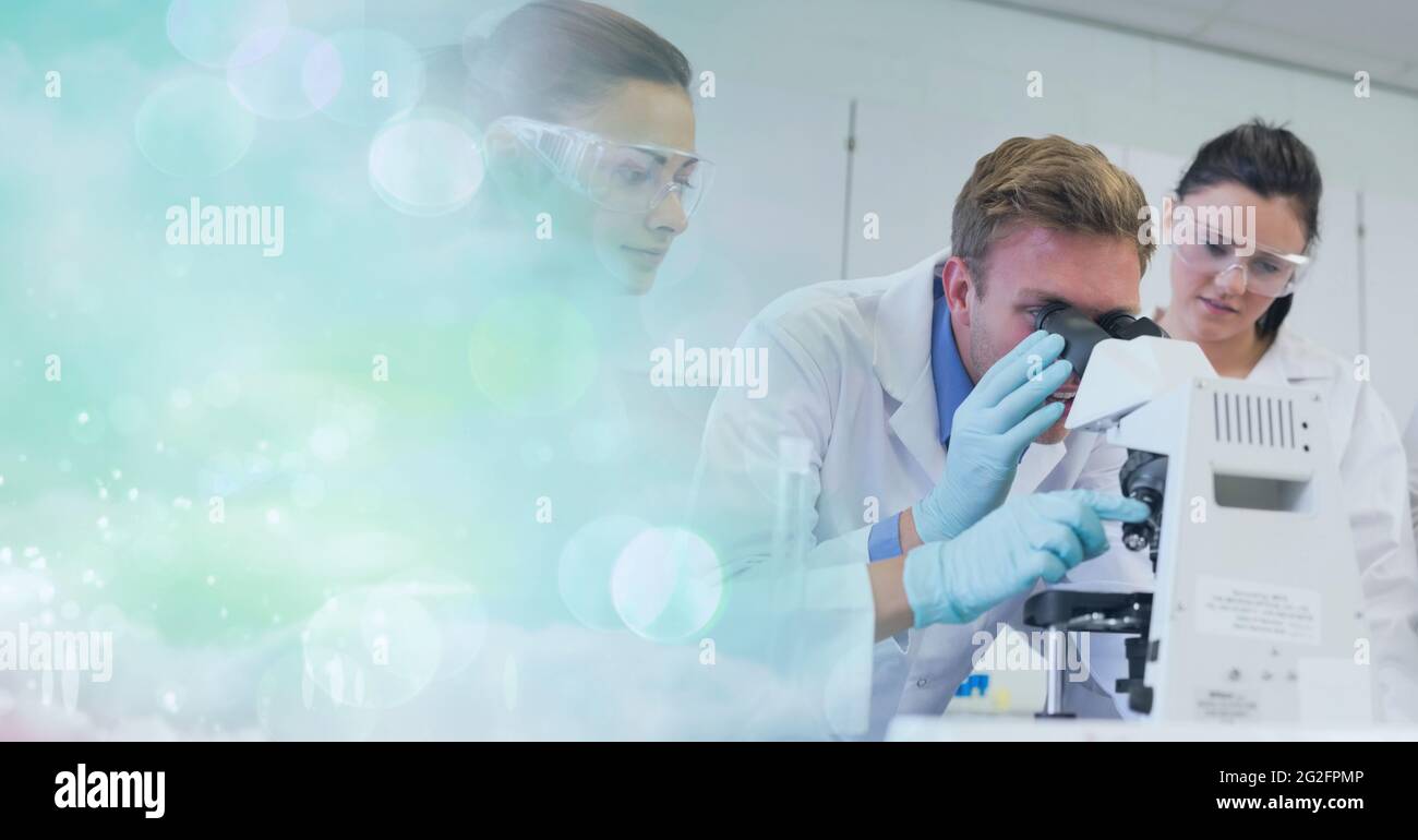 Composition of male scientist using microscope in laboratory with copy ...