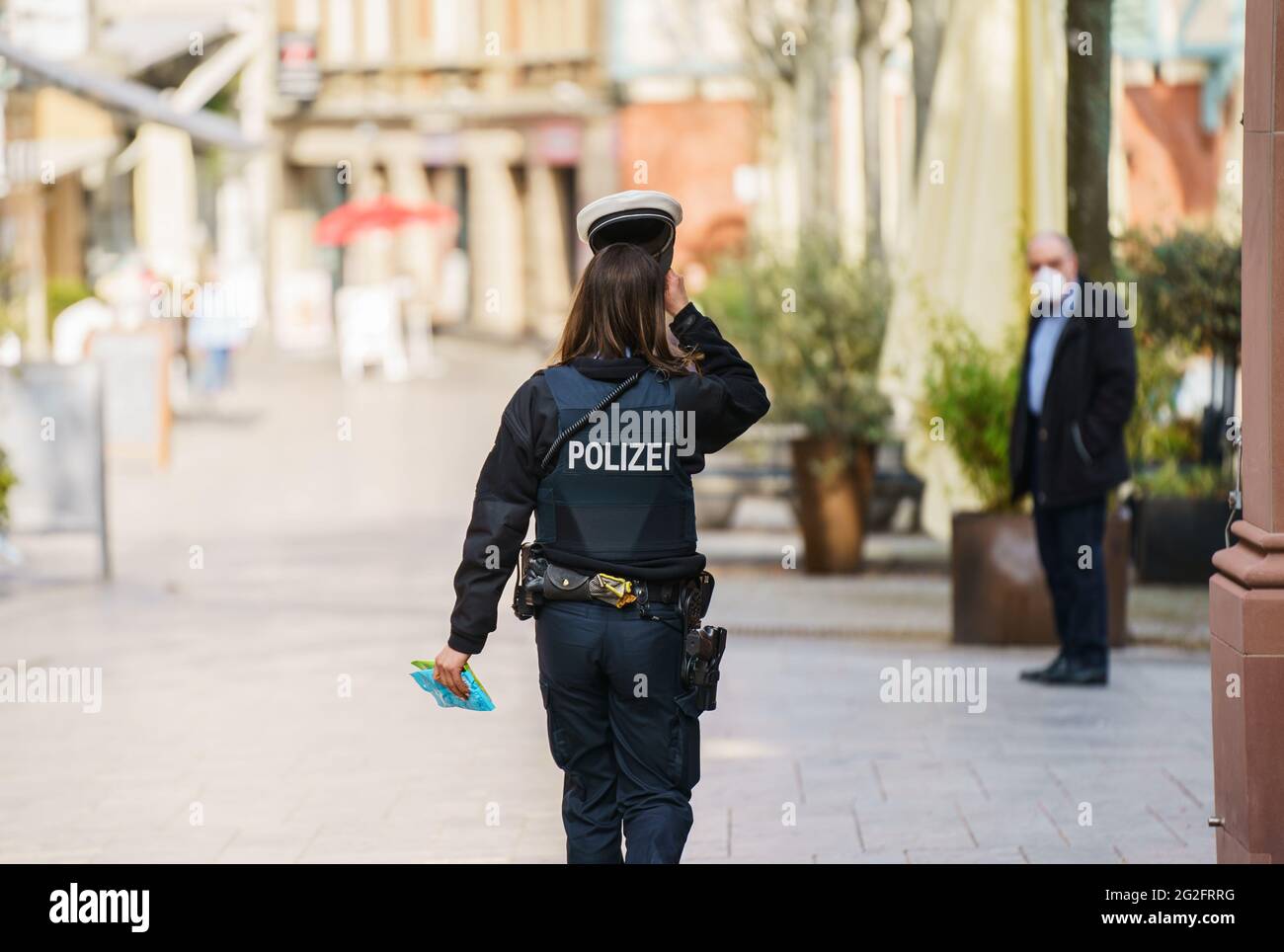 Wiesbaden, Germany. 25th Mar, 2021. A female police officer is walking ...