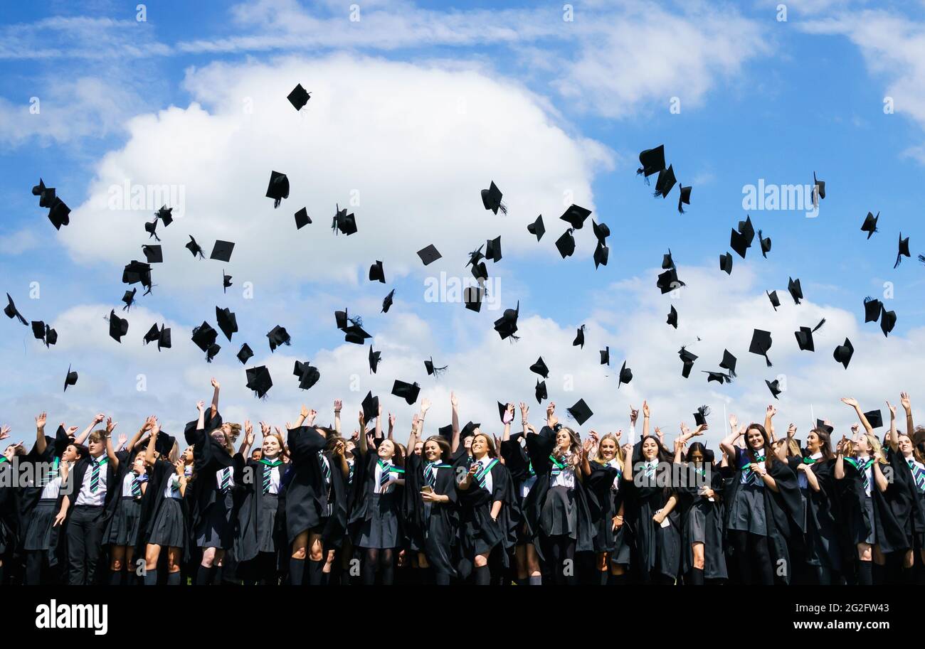 Year 11 pupils throw their mortarboards into the air following a ...