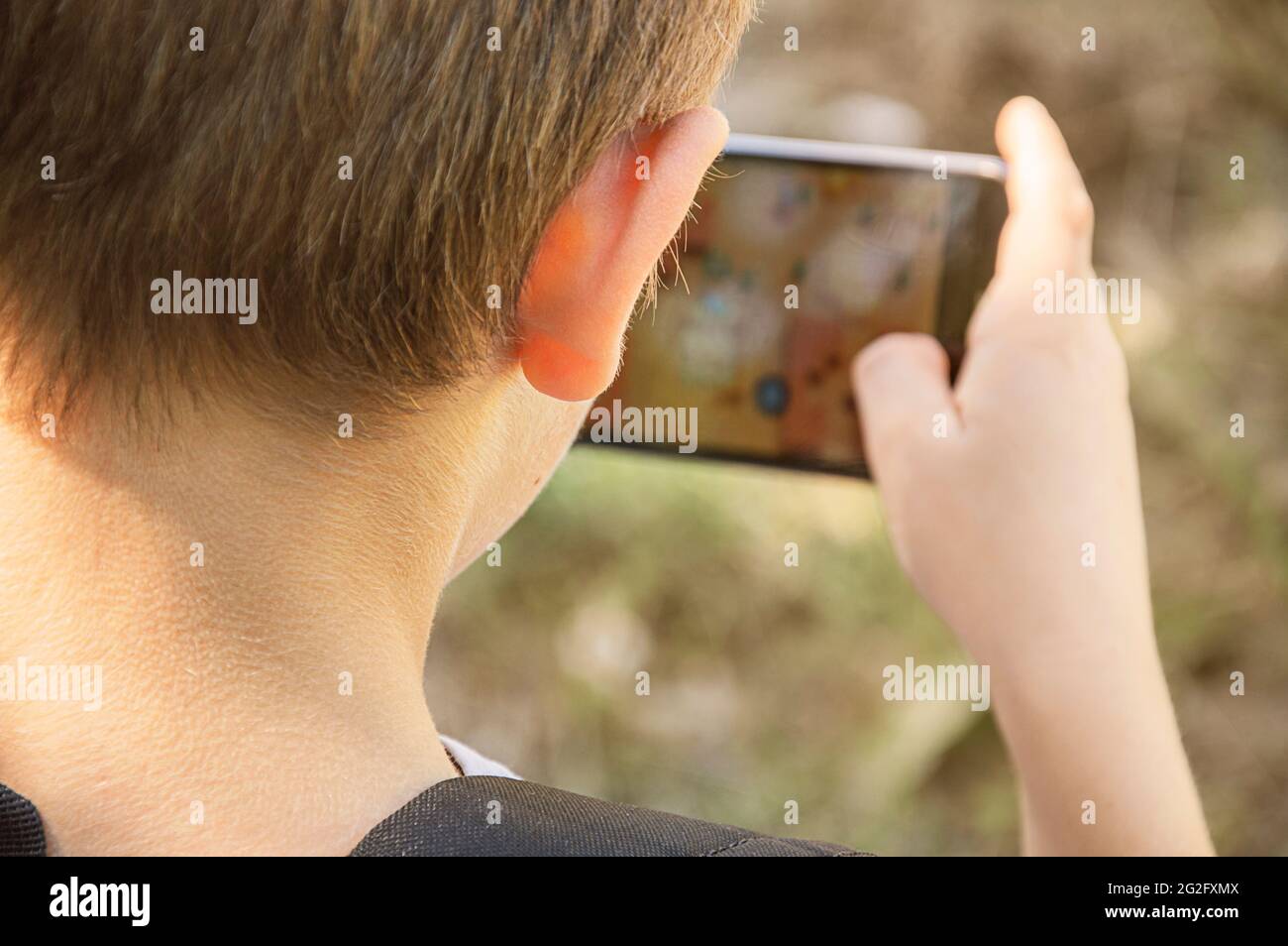 the boy is playing the phone.Close up.Back view Stock Photo - Alamy