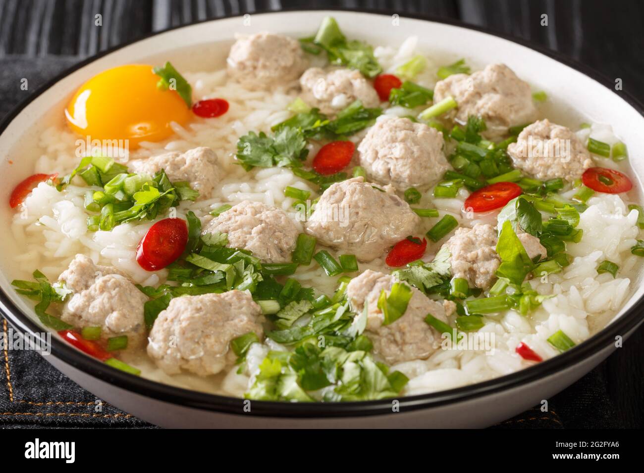 Easy Thai rice soup with meatballs Khao tom moo closeup in the plate on ...