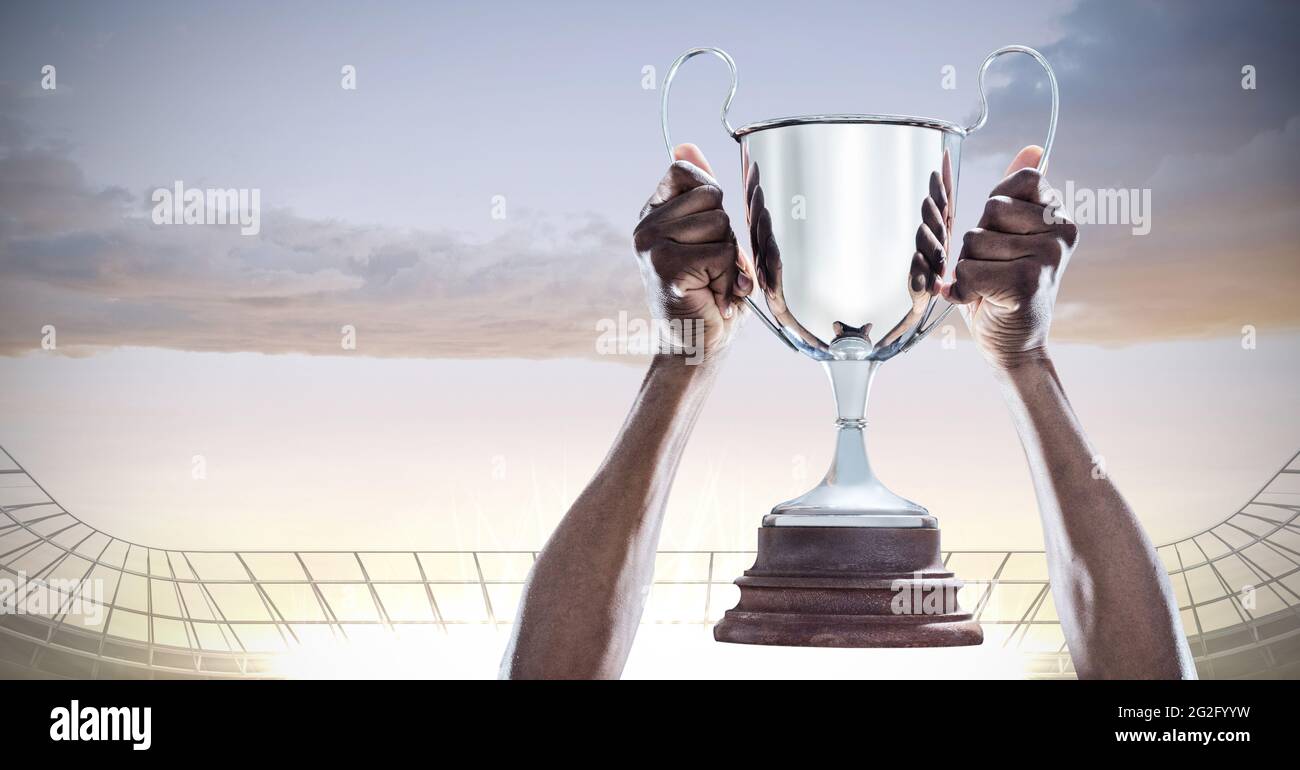 Composition of sportsman celebrating victory, holding trophy at stadium ...