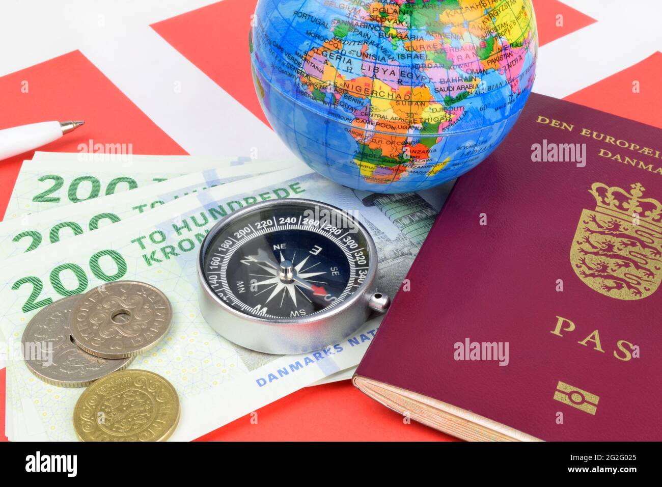 A still life of Danish travel objects, cash, kroner, passport, compass ...